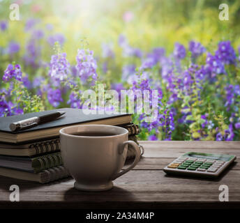 Cup of coffee, notebooks, calculator and pen on light wooden background ...