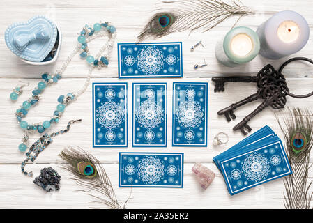 Blue tarot cards and key to the fate on white wooden table background ...