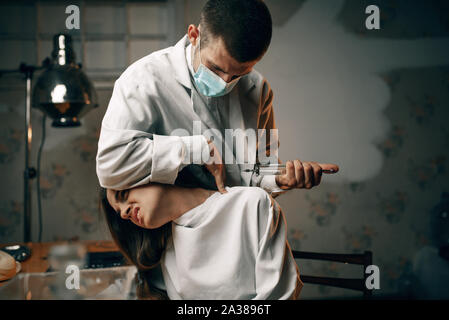 Psychiatrist with syringe makes a sedative injection to crazy female ...