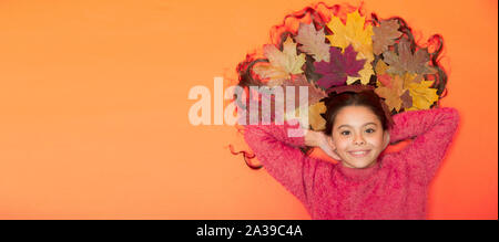 Im hairdresser. Happy girl with colorful leaves in hair. Small child in ...