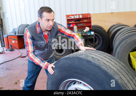 Man carrying two tires outdoors Stock Photo - Alamy
