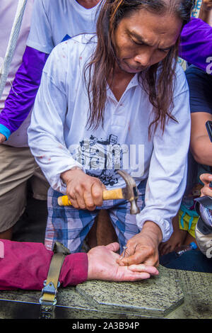 Filippino man hand nailed to a cross during a Good Friday crucifixion ...
