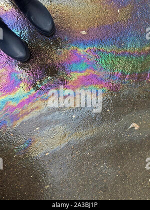 Rain boots on oil spill Stock Photo - Alamy