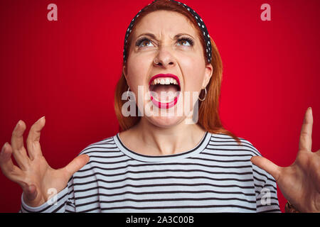 Redhead woman wearing navy striped t-shirt standing over isolated white ...