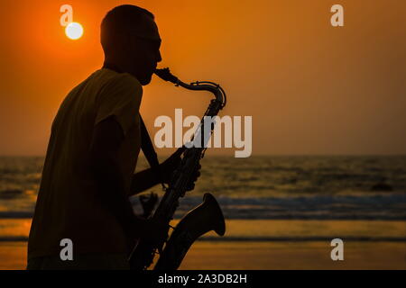 Saxophone player at sunset on beach in St Lucia in the Caribbean, West ...