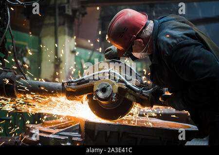 Worker grinding metal with grinding machine. Sparks when grinding iron ...