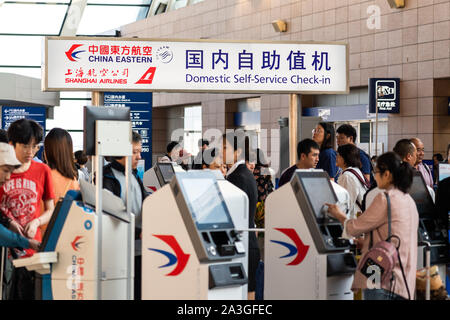 Passengers use the China Eastern Airlines kiosks for airport check-in ...
