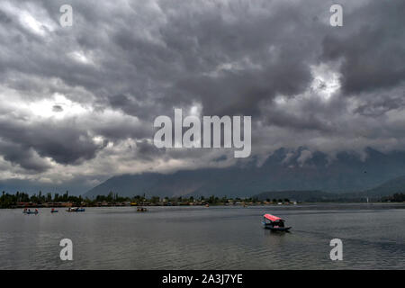 A boatman rows his boat during cloudy weather in Dal Lake Srinagar ...