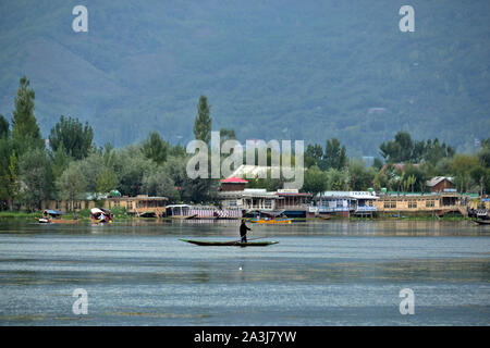 A boatman rows his boat during cloudy weather in Dal Lake Srinagar ...
