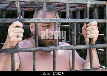 Bearded man in jail or prison. Men in a cage outdoor. danger or ...