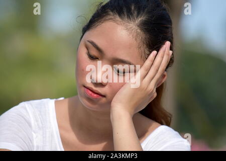 A sad and upset young Asian female doctor or medical worker in scrubs ...