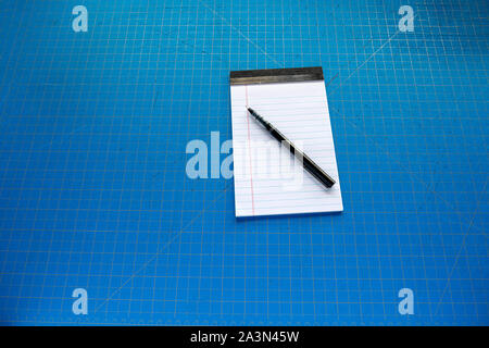 Horizontal shot of a Blank Legal Pad On a Blue cutting board with copy ...
