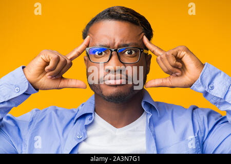 Afro Guy Concentrating Pointing Fingers At Forehead, Studio Shot Stock ...