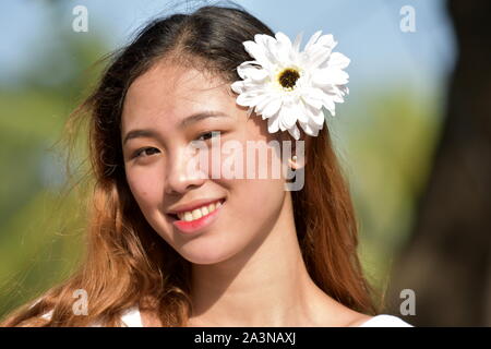 Youthful Diverse Female Smiling With A Daisy Stock Photo - Alamy