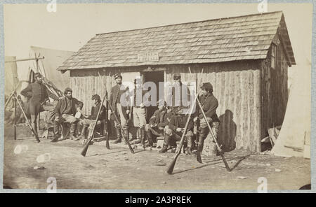 Soldiers outside a log cabin winter quarters, identified as "Pine ...