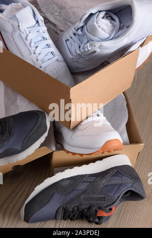 Cardboard boxes with white sneakers on light background Stock Photo - Alamy