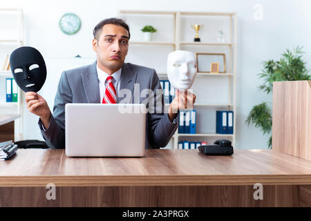 The businessman wearing mask in hypocrisy concept Stock Photo - Alamy