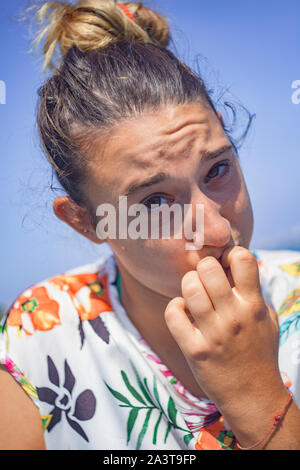 Stressed young woman eating her nails Stock Photo - Alamy
