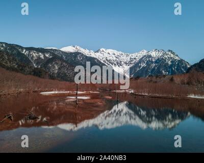 Snow-covered Japanese Alps reflected in Lake Taisho Pond, Kamikochi ...
