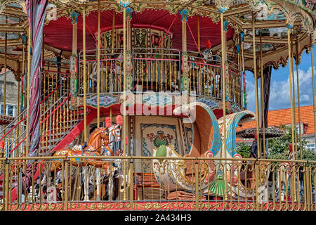 Colourful merry-go-round / carousel on the seafront on a sunny summer's ...