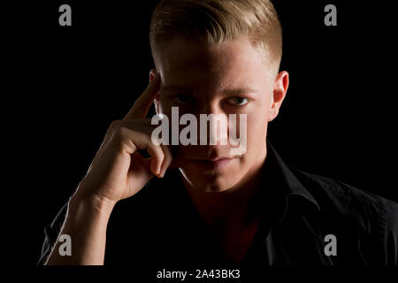 Low key portrait of young alluring man looking straight Stock Photo - Alamy