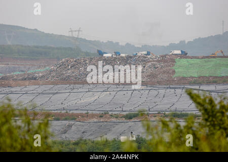 Chinese workers sort out and bury kitchen waste at the Jiangcungou ...