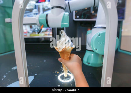 A robot arm makes an ice cream for customers at a fastfood restaurant ...