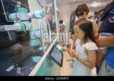 A robot arm makes an ice cream for customers at a fastfood restaurant ...