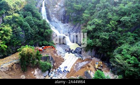 Chinese workers reconstruct a road devastated by floodwater after heavy ...