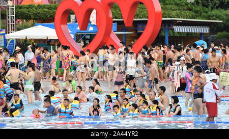 Tourists crowd a swimming pool at the Chimelong Water Park to cool off ...