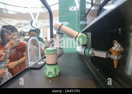 A robot arm makes an ice cream for customers at a fastfood restaurant ...