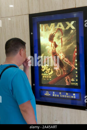 A Chinese filmgoer views a poster of Chinese animated film "Ne Zha" at ...