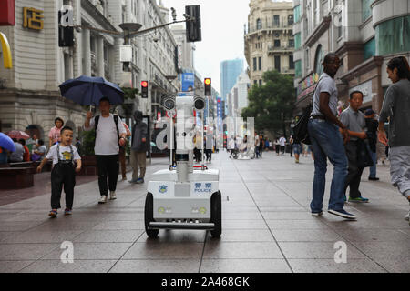 People look at the robot patrolman on Nanjing East Road in Shanghai ...