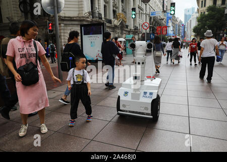 People look at the robot patrolman on Nanjing East Road in Shanghai ...