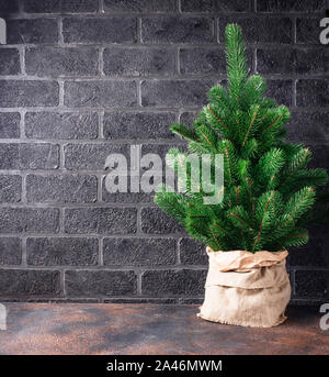 Christmas tree on brick wall background Stock Photo - Alamy