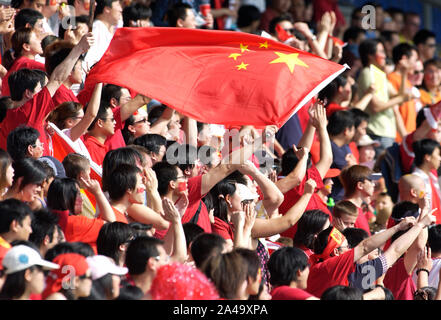 Chinese football fans wave national flags and shout slogans to show ...
