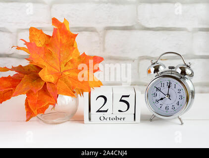 October 25 wooden calendar, white on a black background, pink roses lie ...
