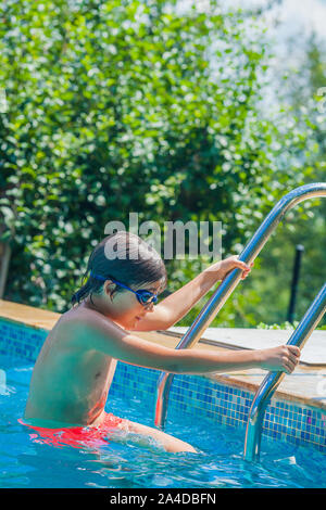 Teenage boy getting out of swimming pool Stock Photo: 104920809 - Alamy