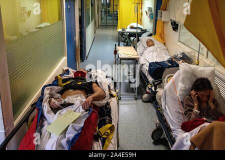 OVERLOAD AND CROWDING, PATIENTS WAIT IN THE CORRIDOR, EMERGENCY ROOM OF ...