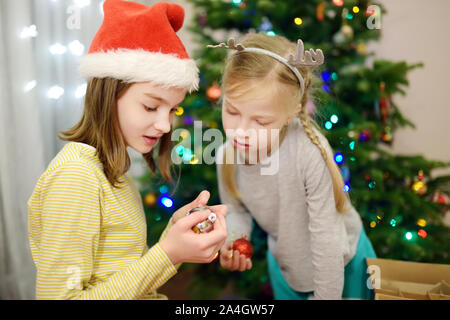 Sisters decorating Christmas tree at home Stock Photo - Alamy