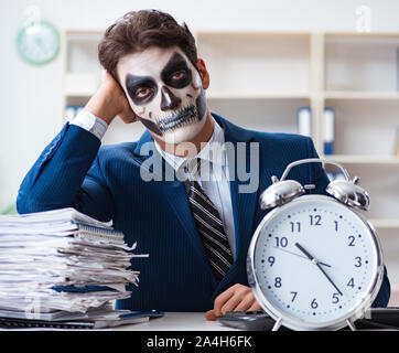 Businessman with scary face mask working late in office Stock Photo - Alamy