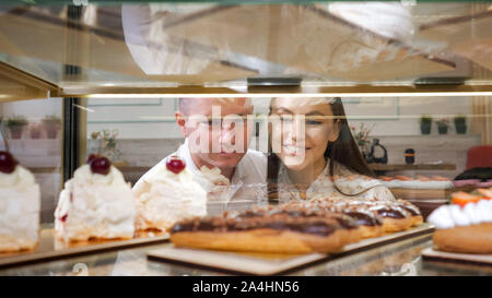 Woman in a cafe chooses a dessert Stock Photo - Alamy