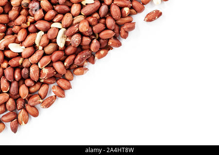 peeled peanuts sprinkled on a white background. nutritious vegetable ...