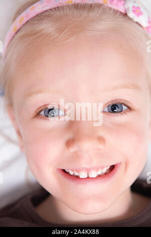Portrait of a blonde girl with blue eyes without makeup on a light ...