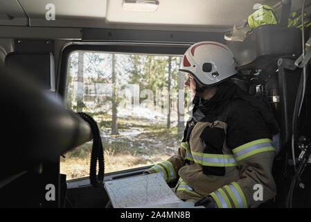 Firefighter looking through window while sitting in fire truck Stock ...