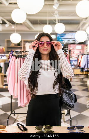 A brunette woman in sunglasses with long hair and her daughter who eats ...