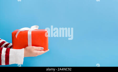 Woman in blue sweater with gift box for Valentine's Day on grey ...
