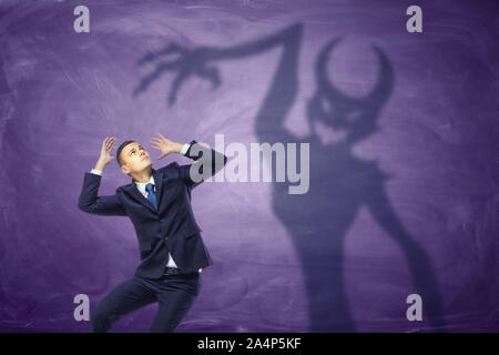 Young Businessman Afraid Of Devil Shadow Falling On Wall Stock Photo ...