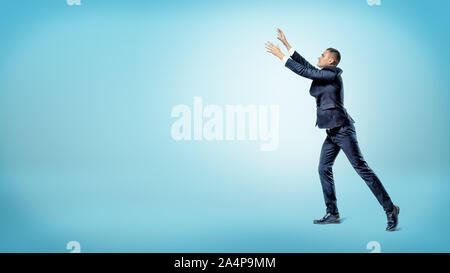 business man reaching to grab something from above his head, man in ...