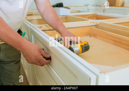 Installation of measuring drawers handles on kitchen cabinets Stock ...